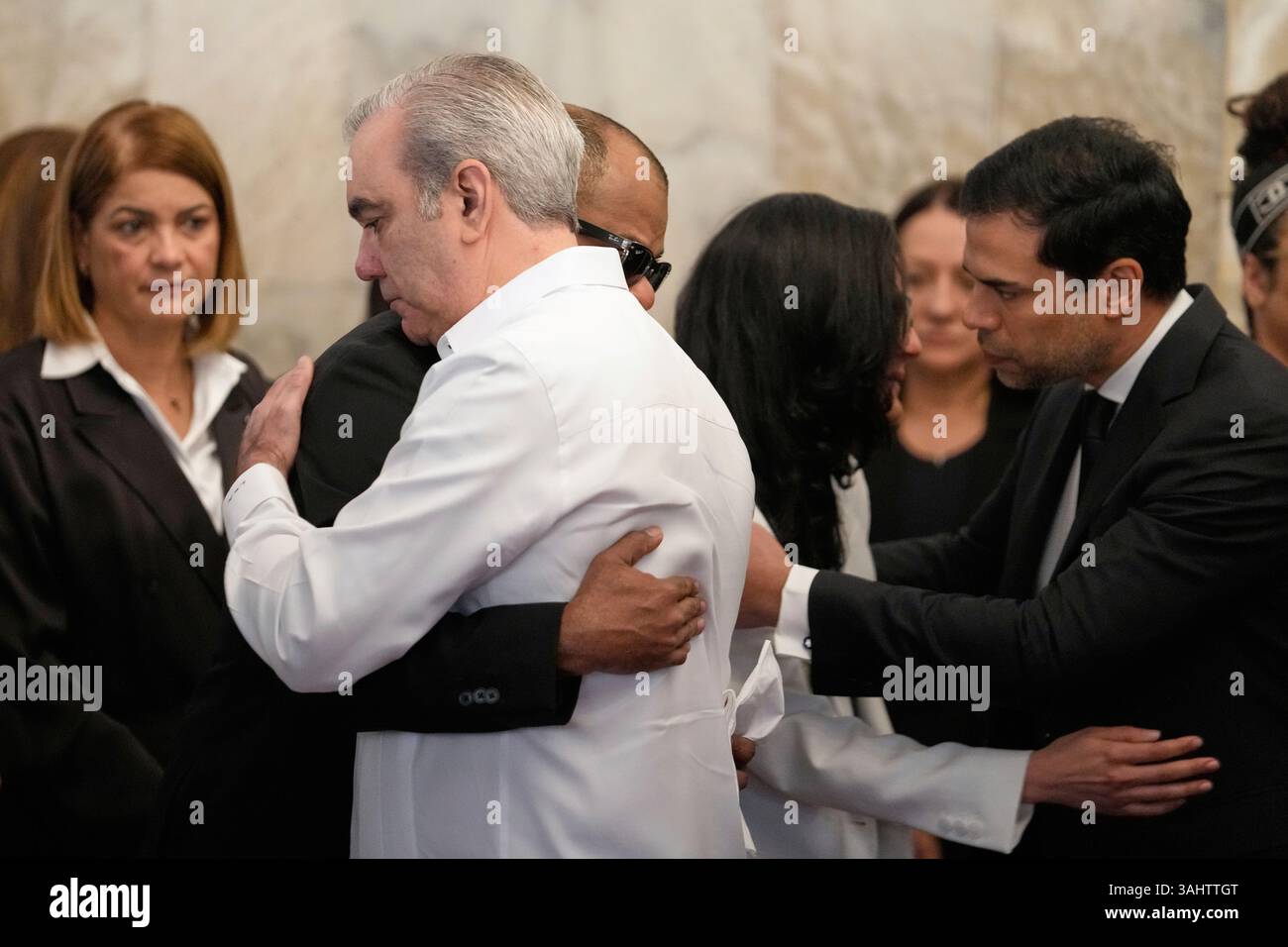 Dominican Republic President Luis Abinader, front, consoles the family ...