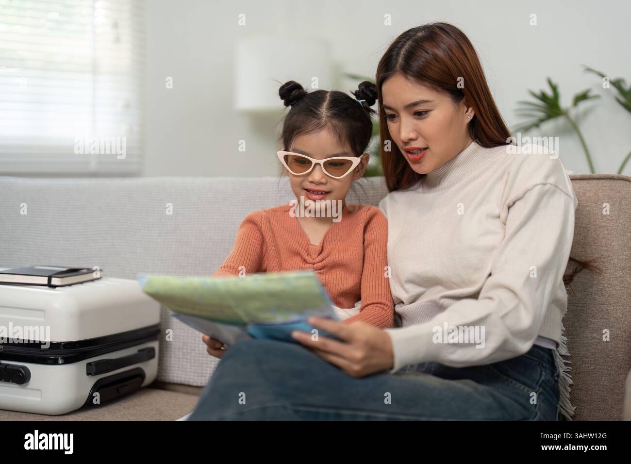 Exploring Destinations Together. A mother and daughter look at maps ...