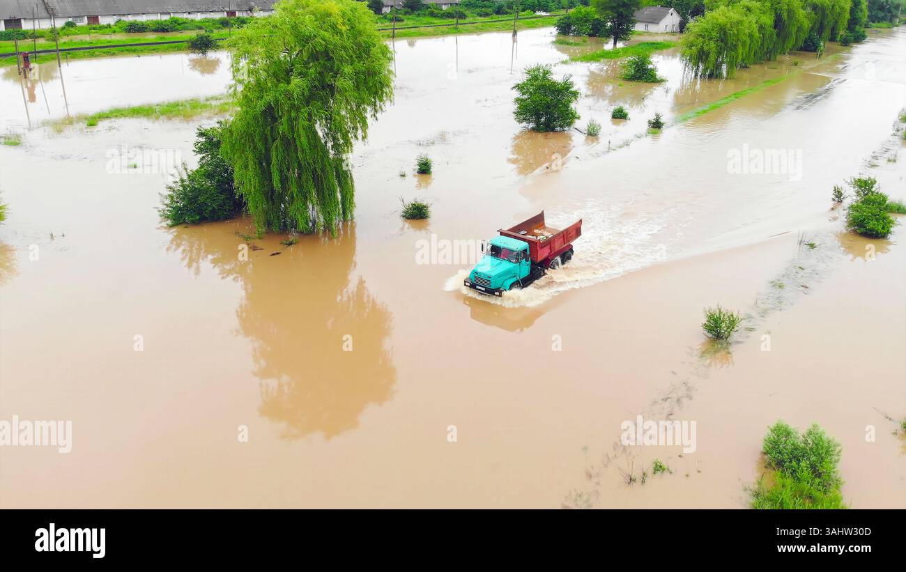 Truck driving through flooded area after heavy rainfall. A truck ...