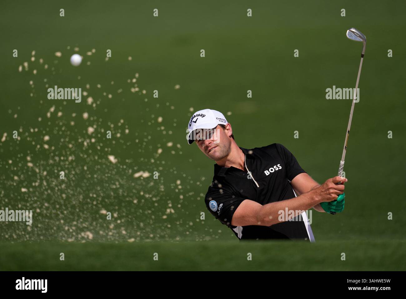 Thomas Detry, of Belgium, hits from the bunker on the second hole ...