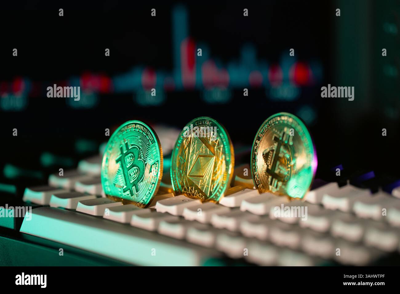 Bitcoin coins on computer keyboard with trading chart in background ...
