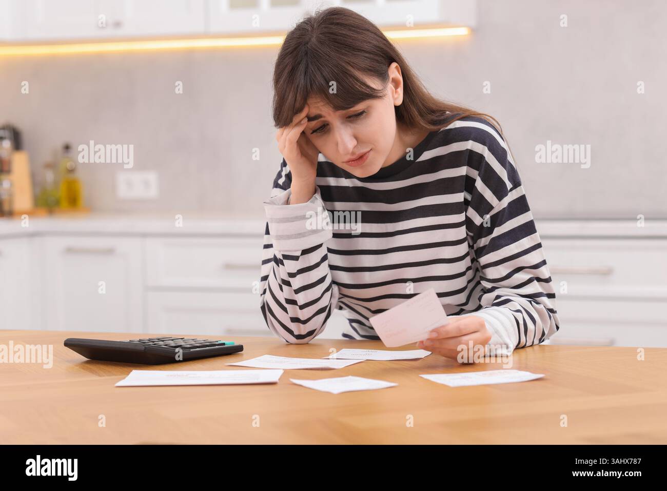 Paying bills. Upset woman with different invoices and calculator at ...
