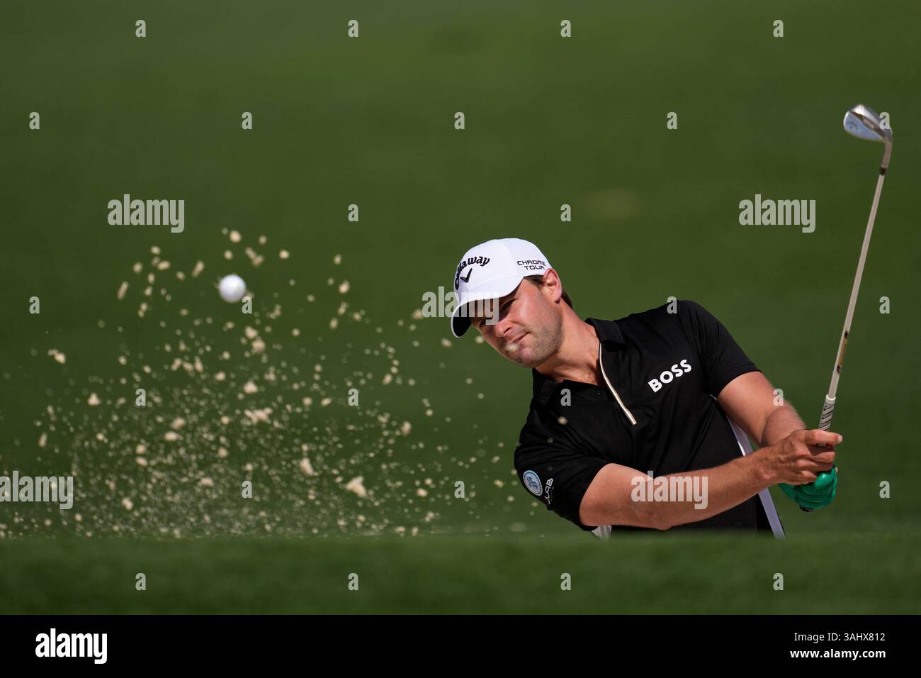 Thomas Detry, of Belgium, hits from the bunker on the second hole ...