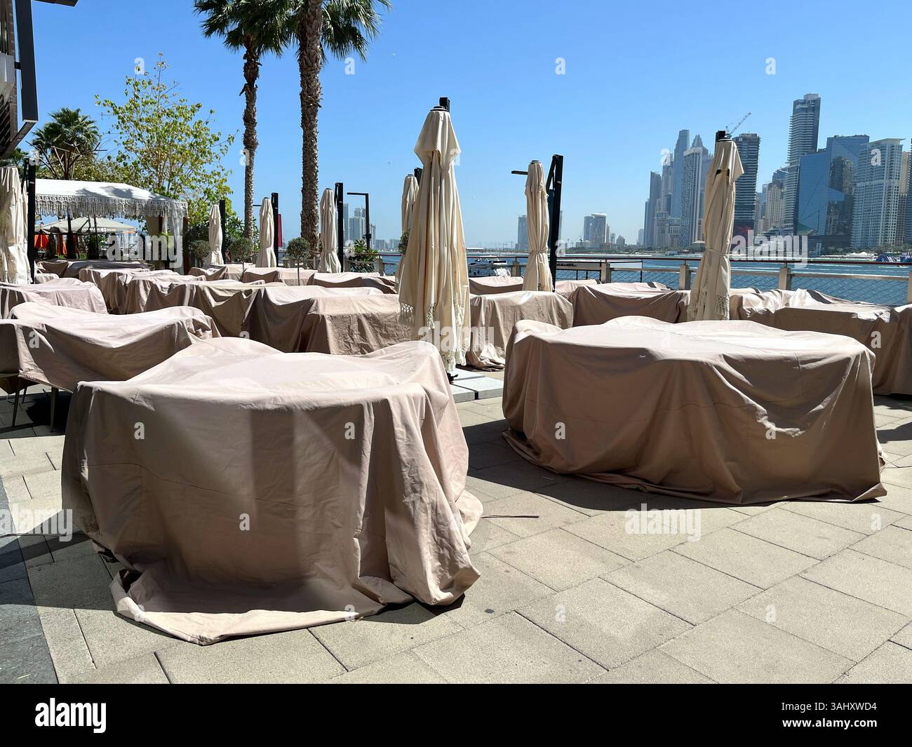 Restaurant terrace with furniture covered with protective fabric on the ...