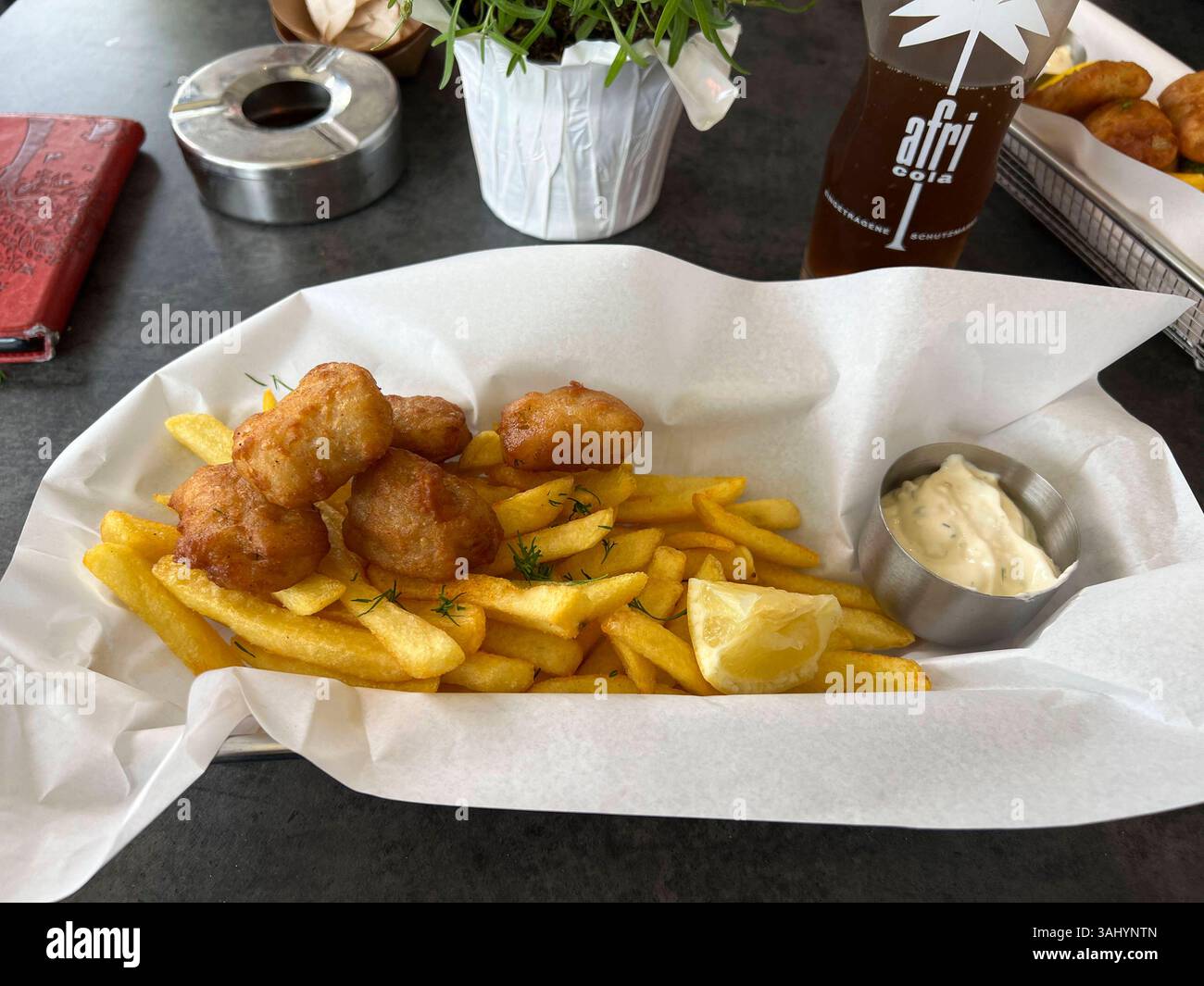 Teller mit einer Portion Fisch und Chips sowie einer Portion Mayonaise ...