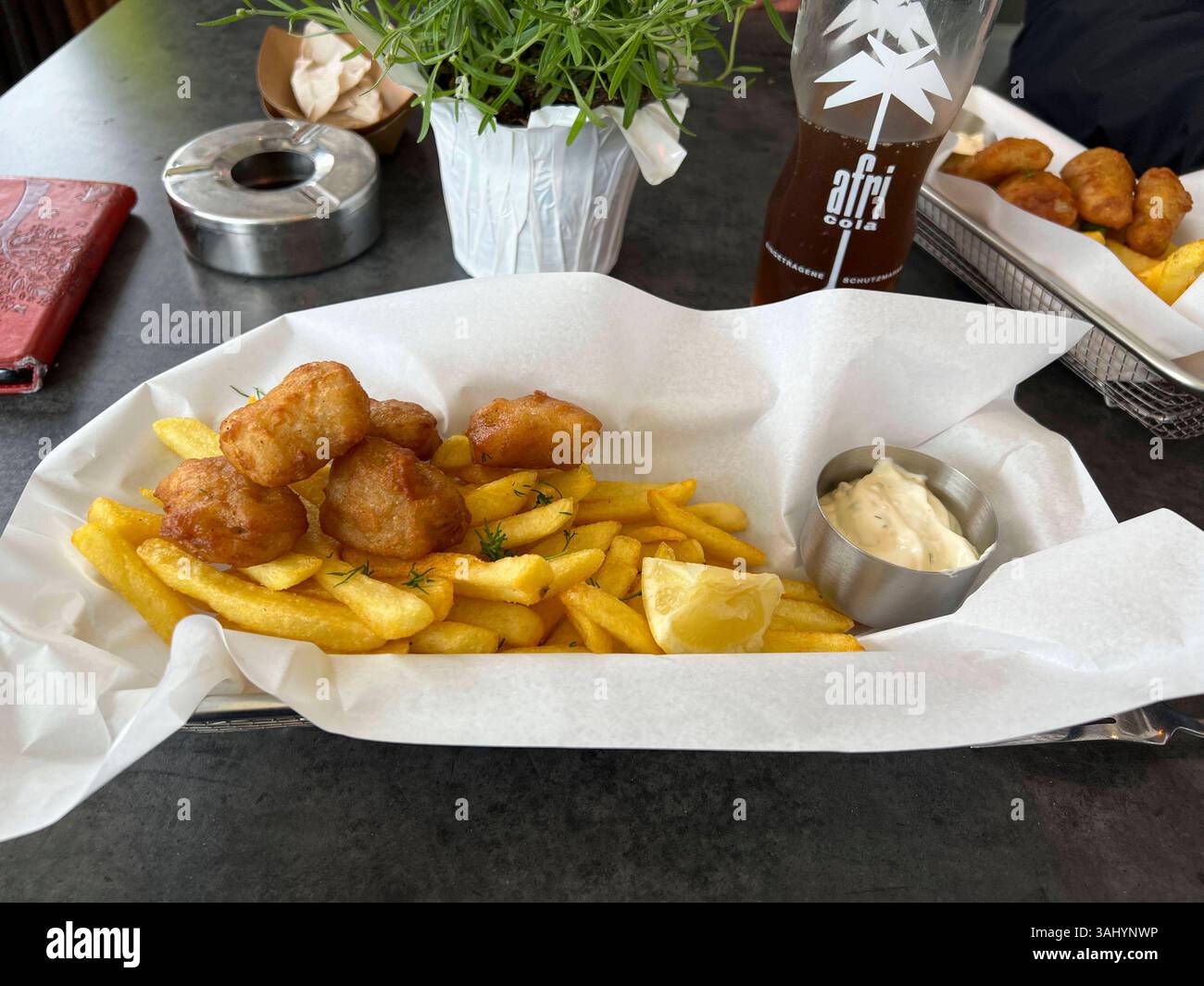 Teller mit einer Portion Fisch und Chips sowie einer Portion Mayonaise ...