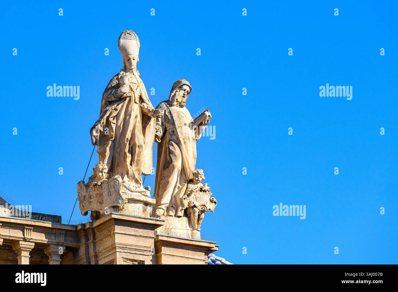 Medieval stone statues of religious saints on top of columns in the ...