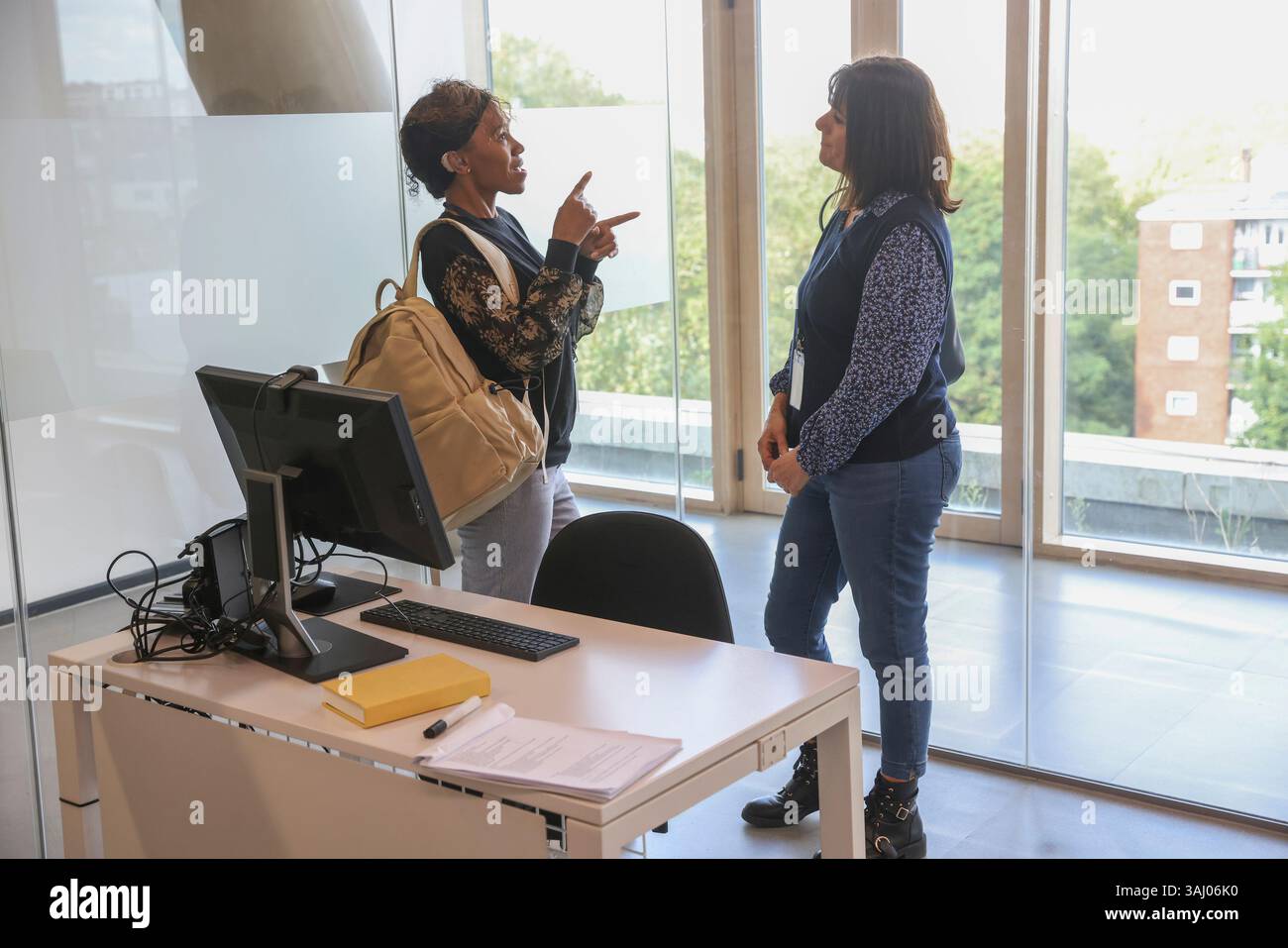 Coworkers using sign language in office Stock Photo - Alamy