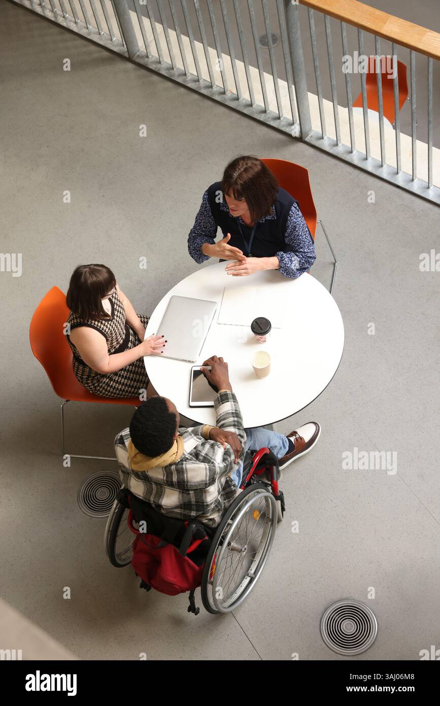 Disabled people talking at table Stock Photo - Alamy