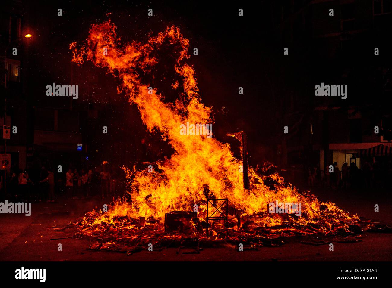 People celebrate St John's Eve (Sant Joan) around a bonfire on a street ...
