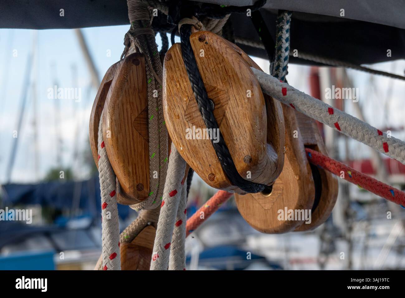 Multiple wooden pulleys are tied with ropes, showcasing craftsmanship ...