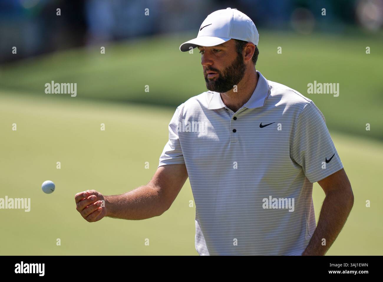Scottie Scheffler tosses his to his caddie on the sixth hole during the ...