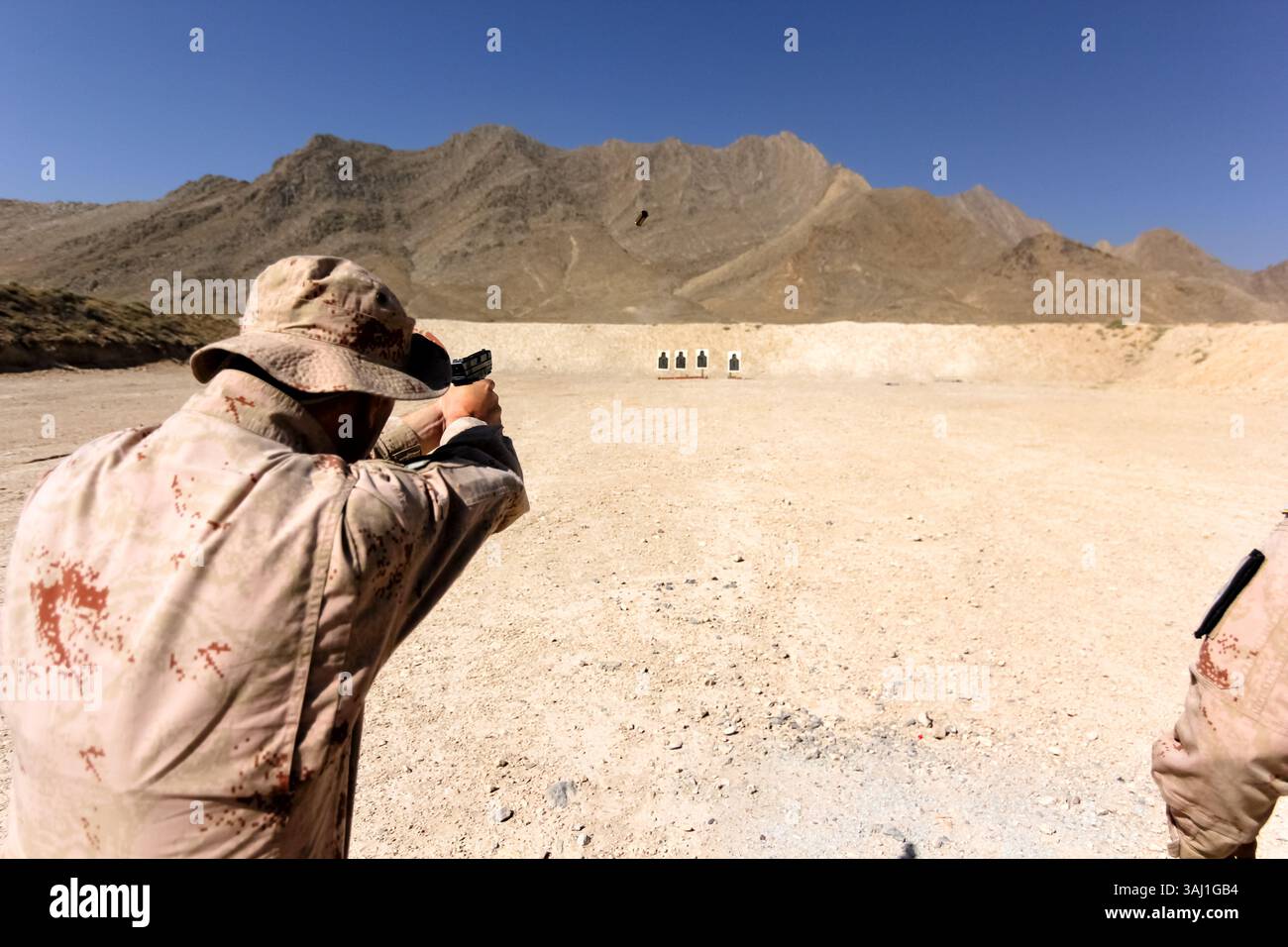 Soldiers practice shooting at a target range with visible silhouette ...