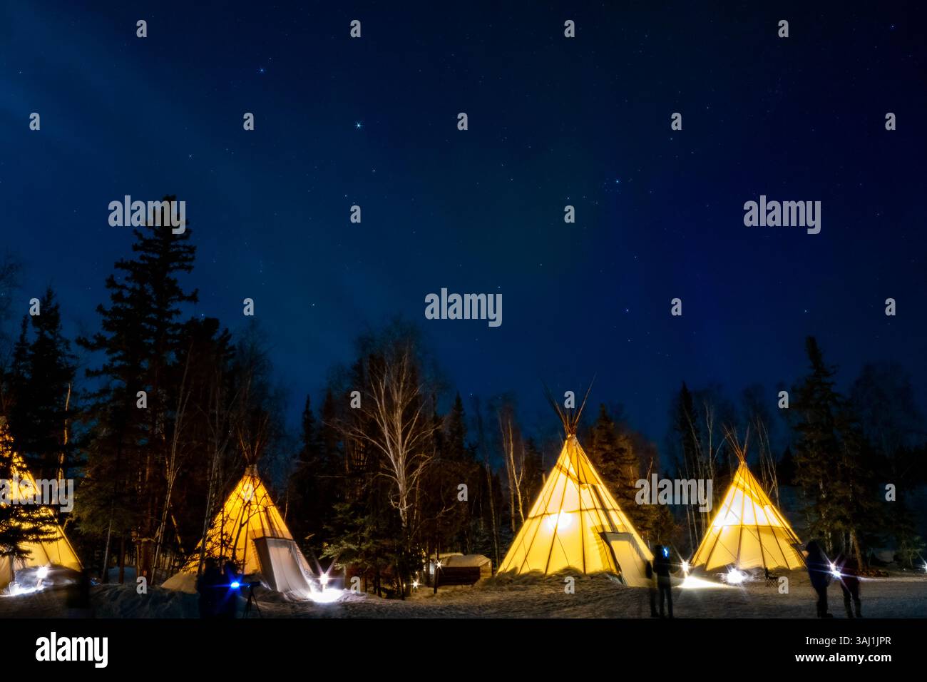 The Northern Lights (Aurora Borealis) above illuminated teepees in the ...
