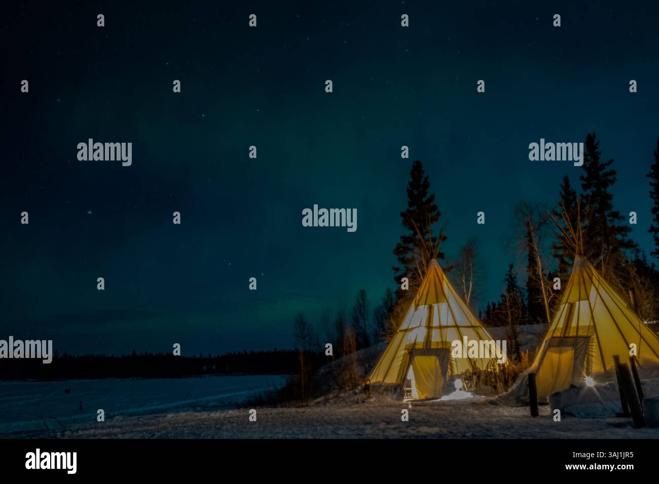 The Northern Lights (Aurora Borealis) above illuminated teepees in the ...