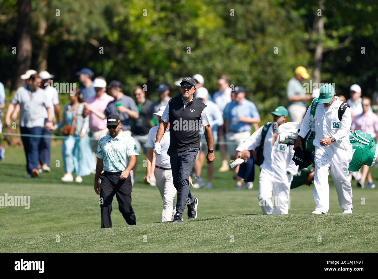 Phil Mickelson and his caddie Jon Yarbrough walk to the sixth green during the first round of ...