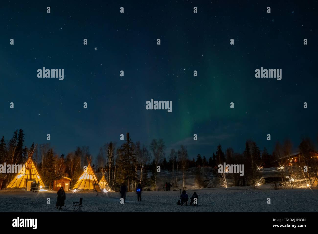 The Northern Lights (Aurora Borealis) above illuminated teepees in the ...