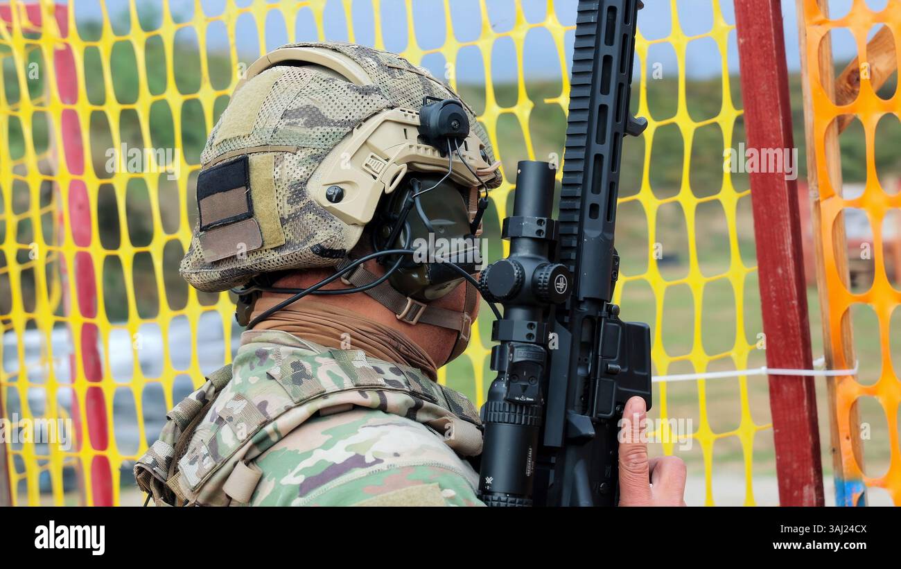 Soldier in Tactical Gear Holding Rifle. A soldier wearing camouflage ...
