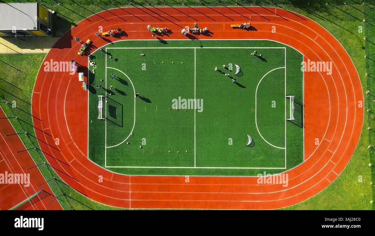 Aerial view of a vibrant sports field and running track. An overhead ...