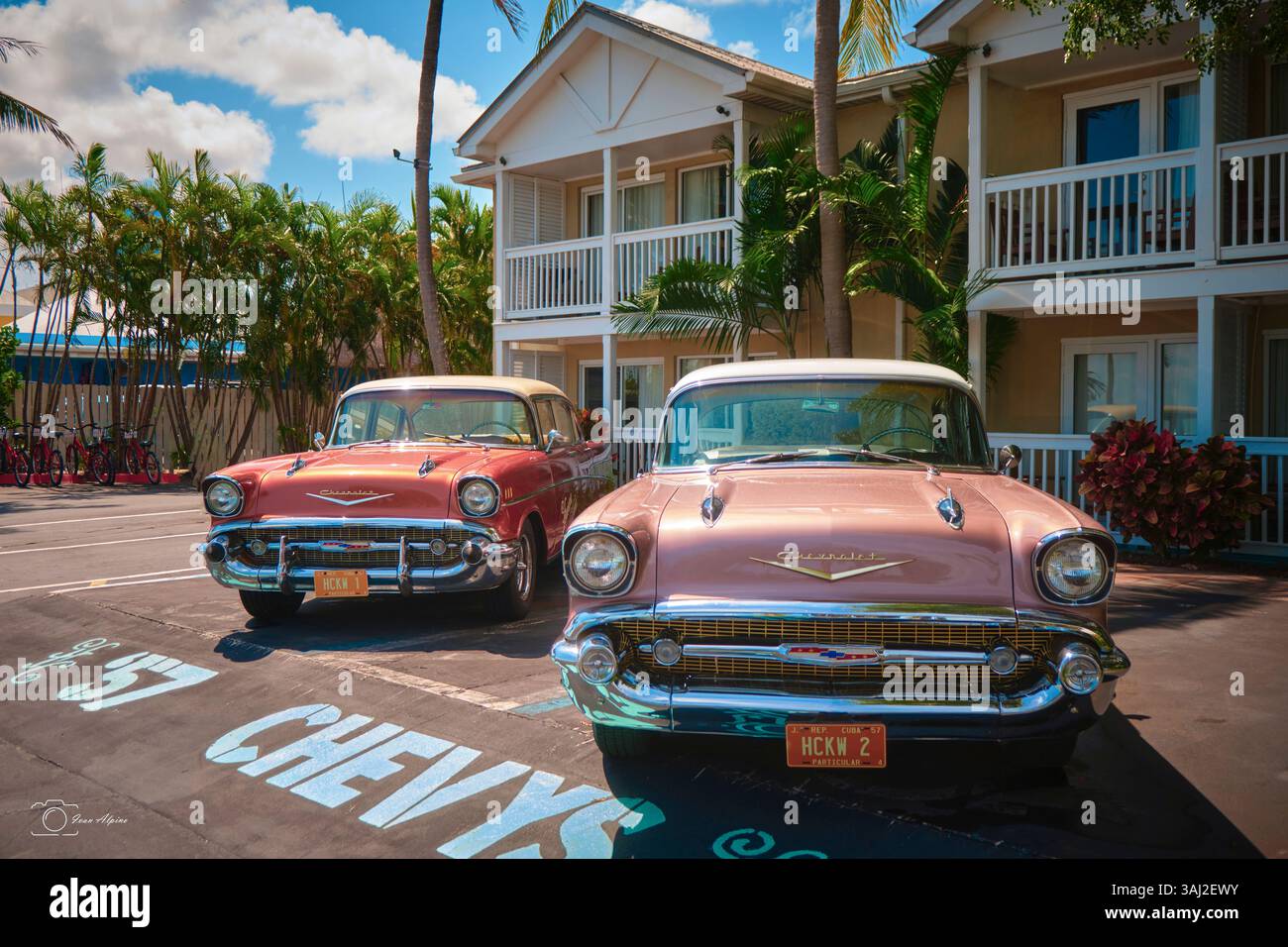 Two classic Chevrolet cars stand proudly against a colorful Cuban ...