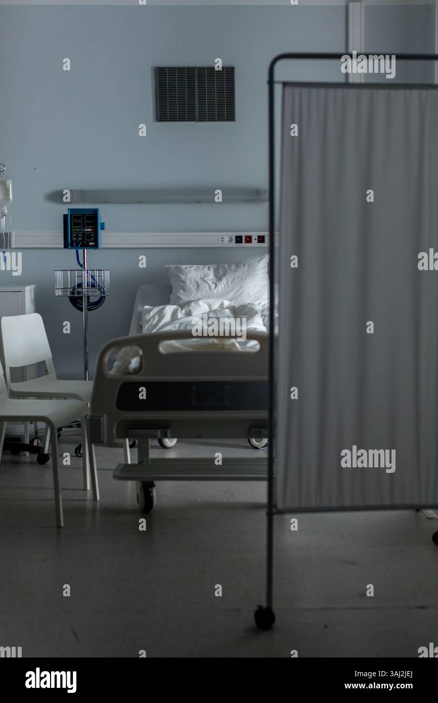 A serene hospital room with a patient bed and privacy screen for ...