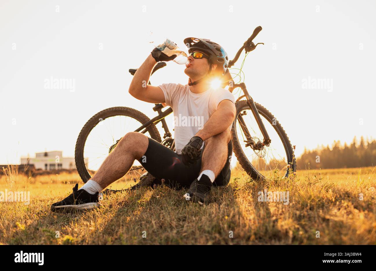A professional mountain bike cyclist drinking water from the bottle ...