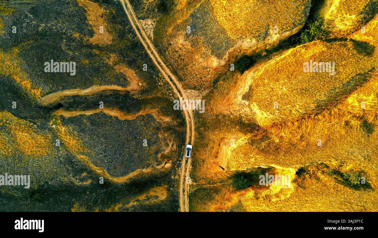 Aerial view of car on rugged off-road terrain. Aerial view of a car ...