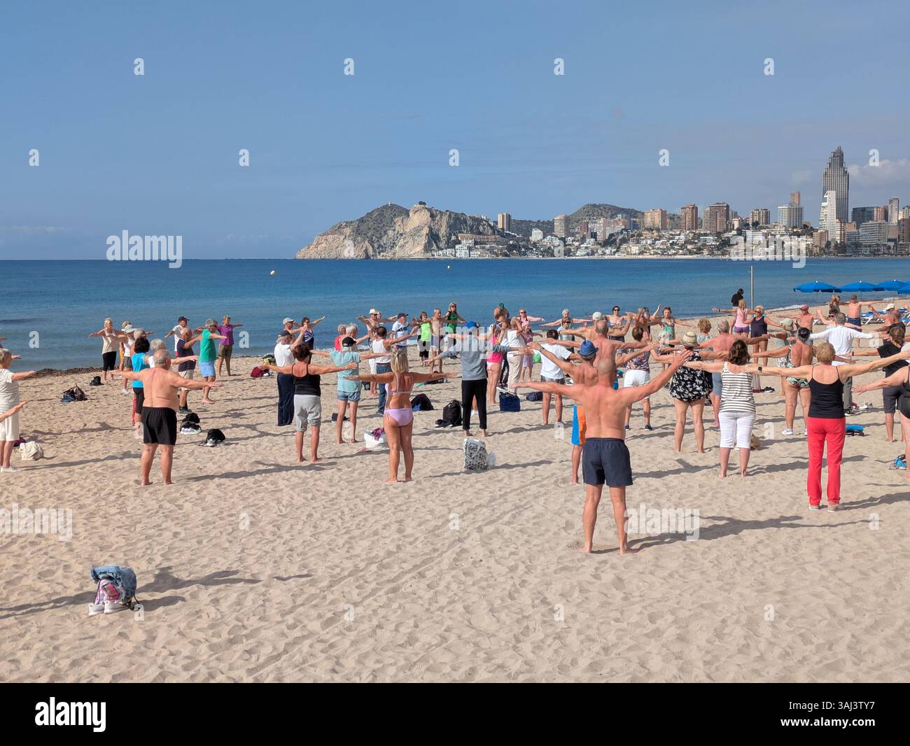 Large group of senior citizens exercising on the beach Stock Photo - Alamy