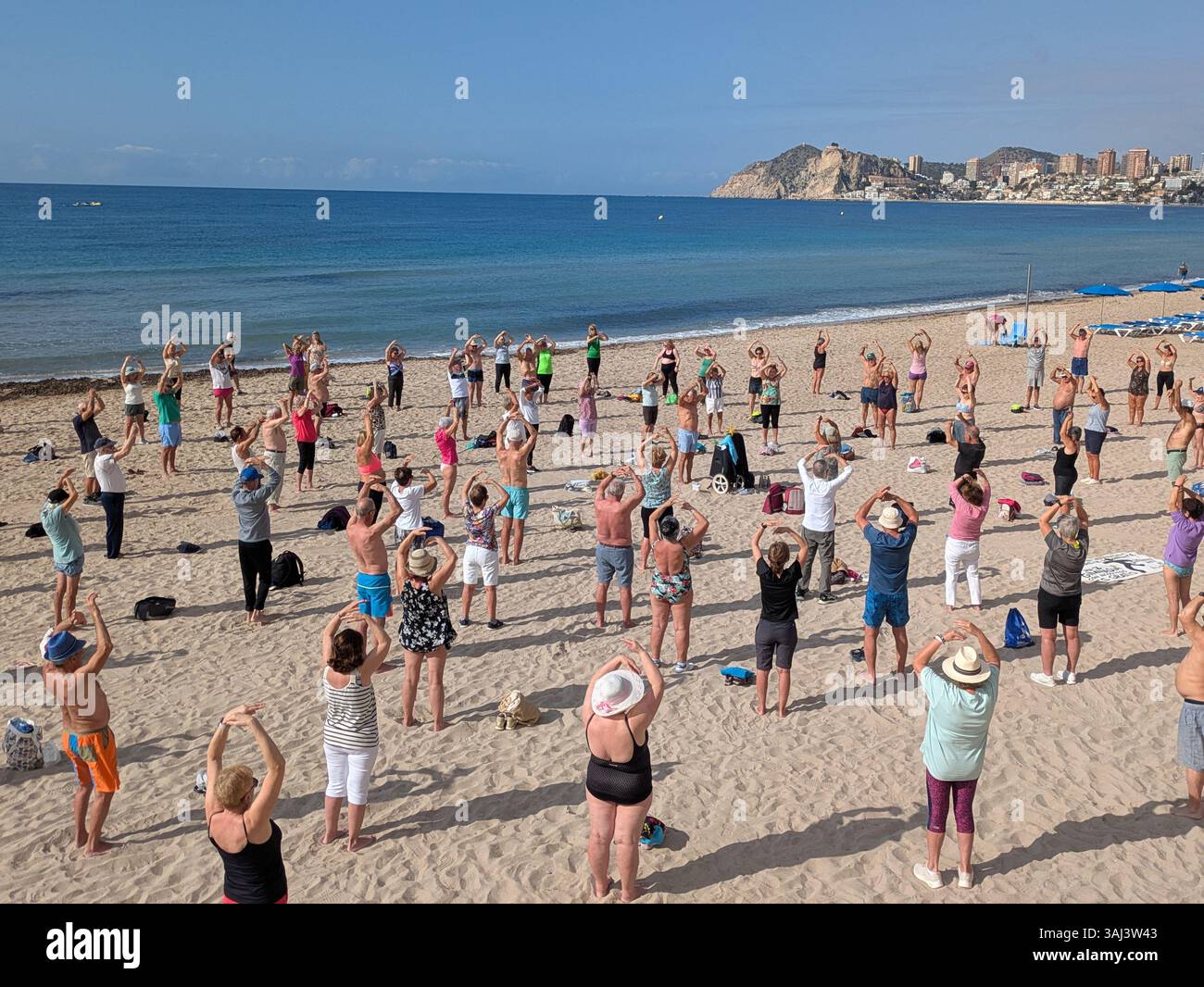 Large group of senior citizens exercising on the beach Stock Photo - Alamy