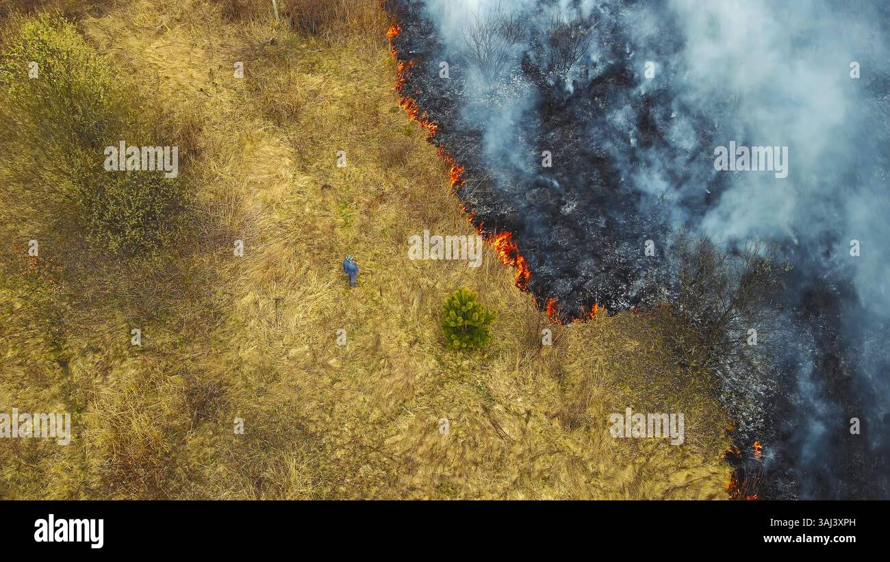 Aerial view of a wildfire spreading in a grassy field. An aerial shot ...