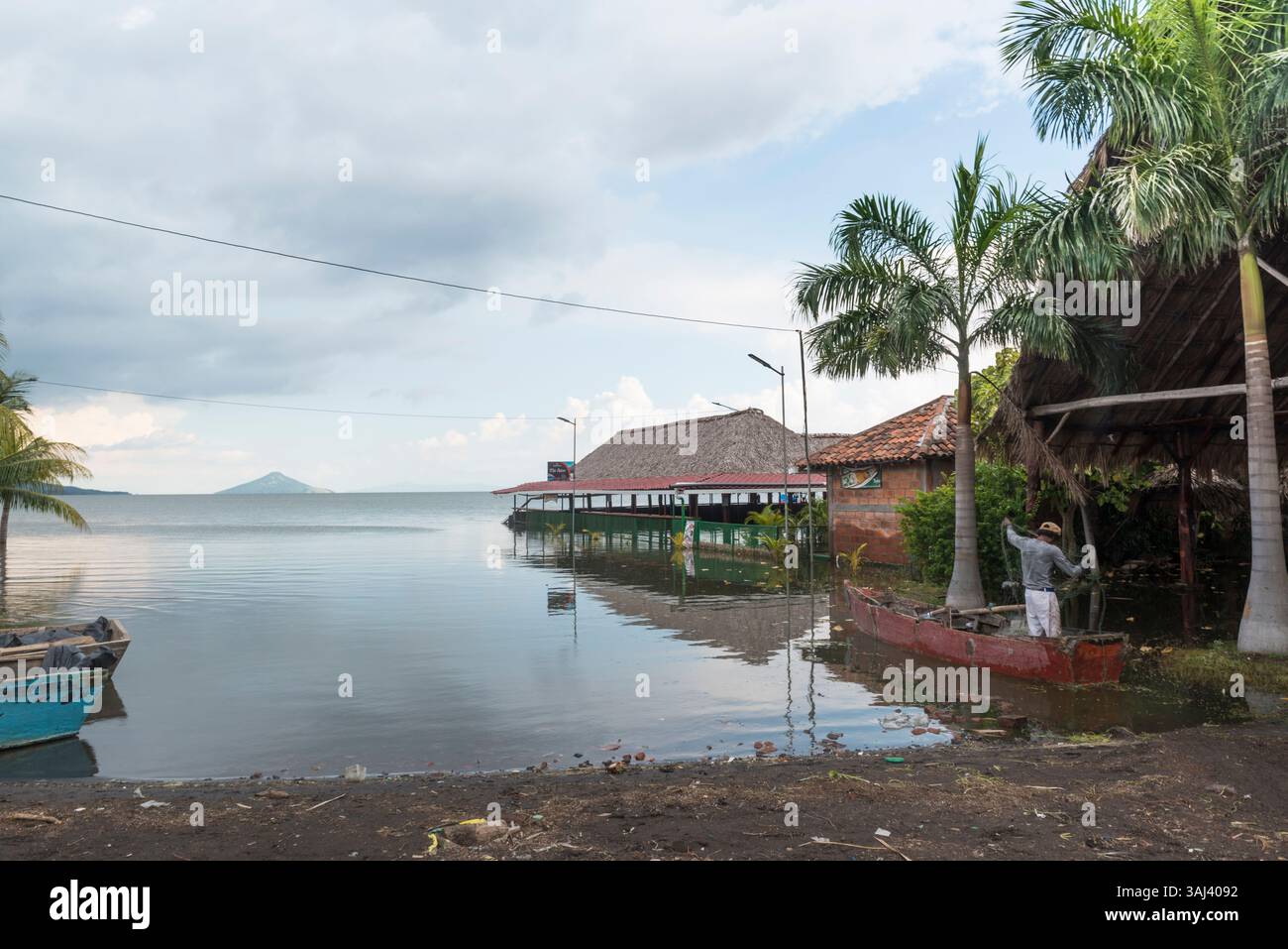 Fisherman arranging his fishing nets on the flooded shore of Puerto ...