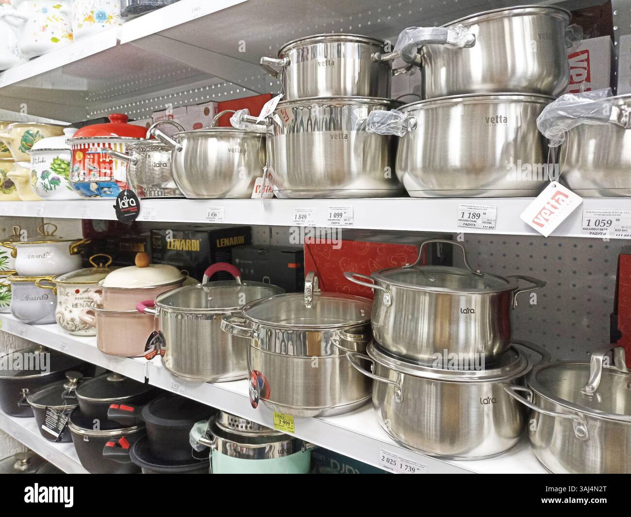 Stainless steel cookware on store shelves with various pots and pans ...