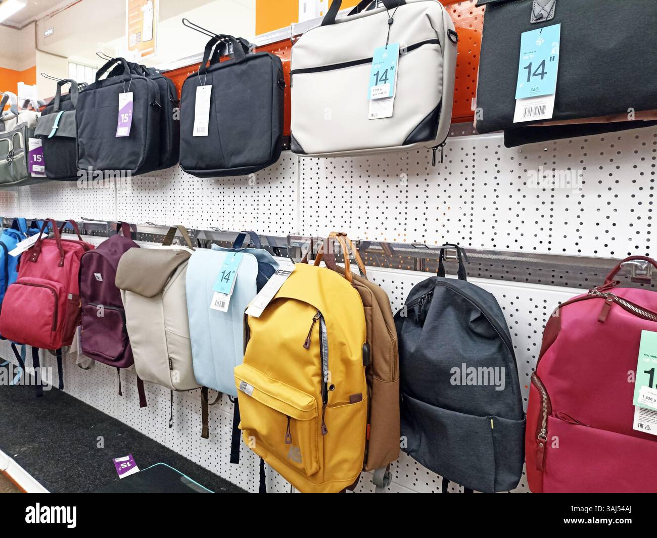 Variety of backpacks displayed in store on pegboard wall with price ...