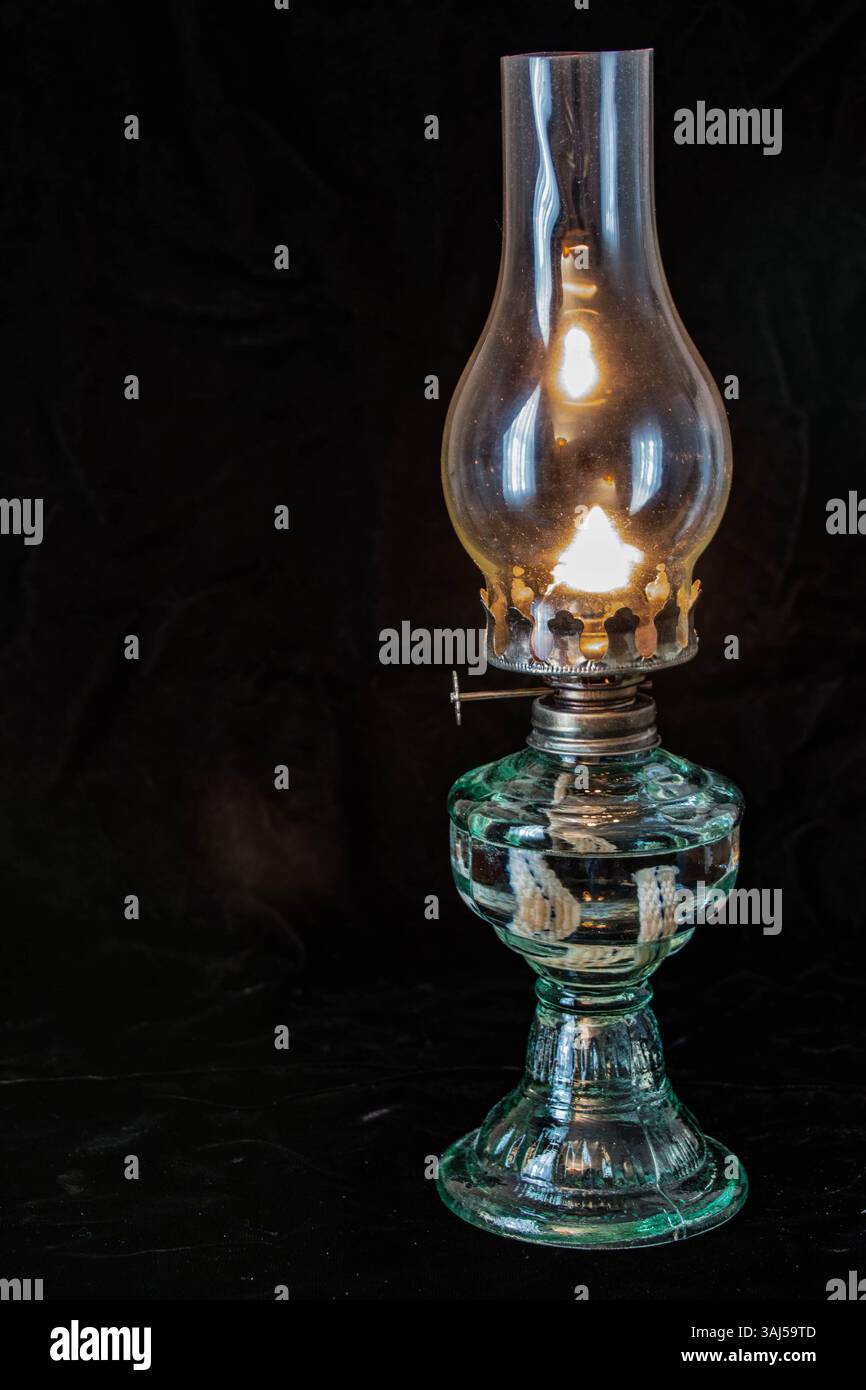 An old fashioned kerosene lamp with a flame on a black background Stock ...