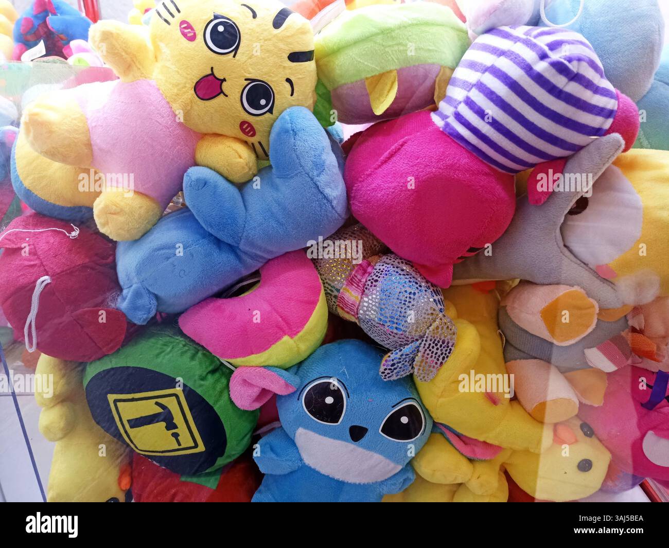 Colorful assortment of plush toys in a claw machine game display Stock ...