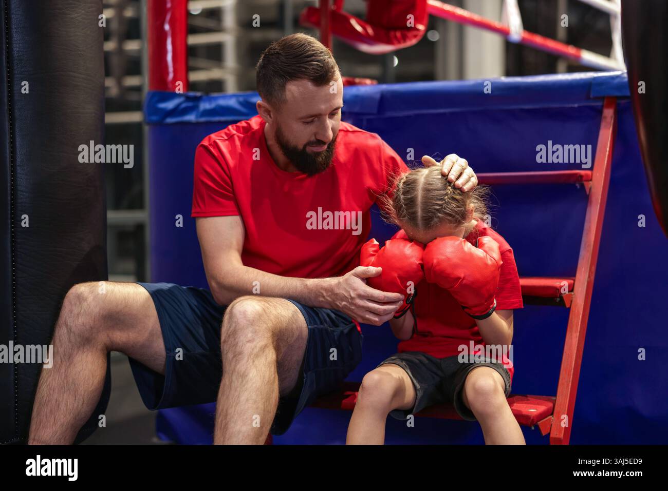 Coach comforting sad girl near boxing ring Stock Photo - Alamy