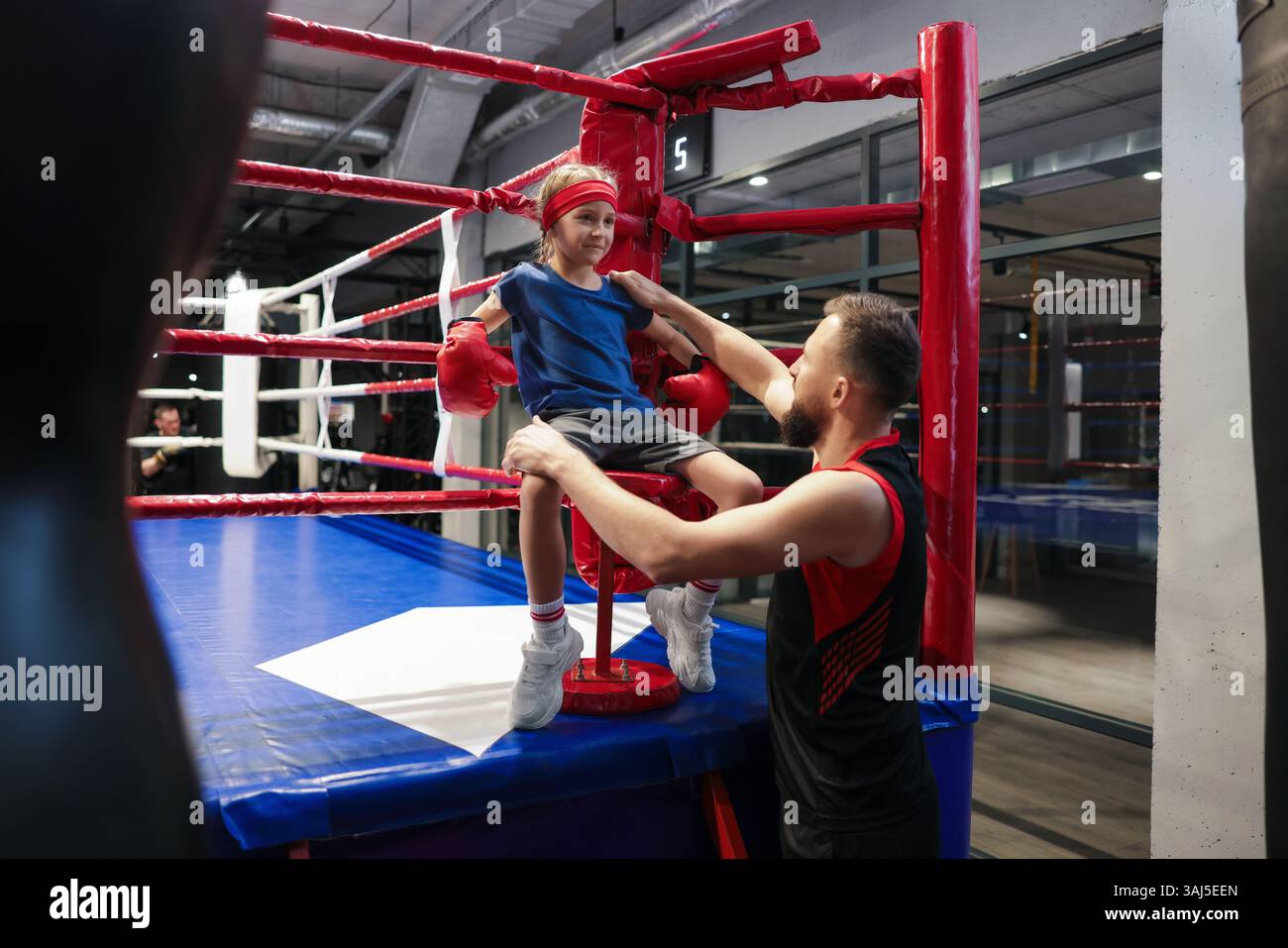 Coach encouraging girl in boxing ring corner Stock Photo - Alamy