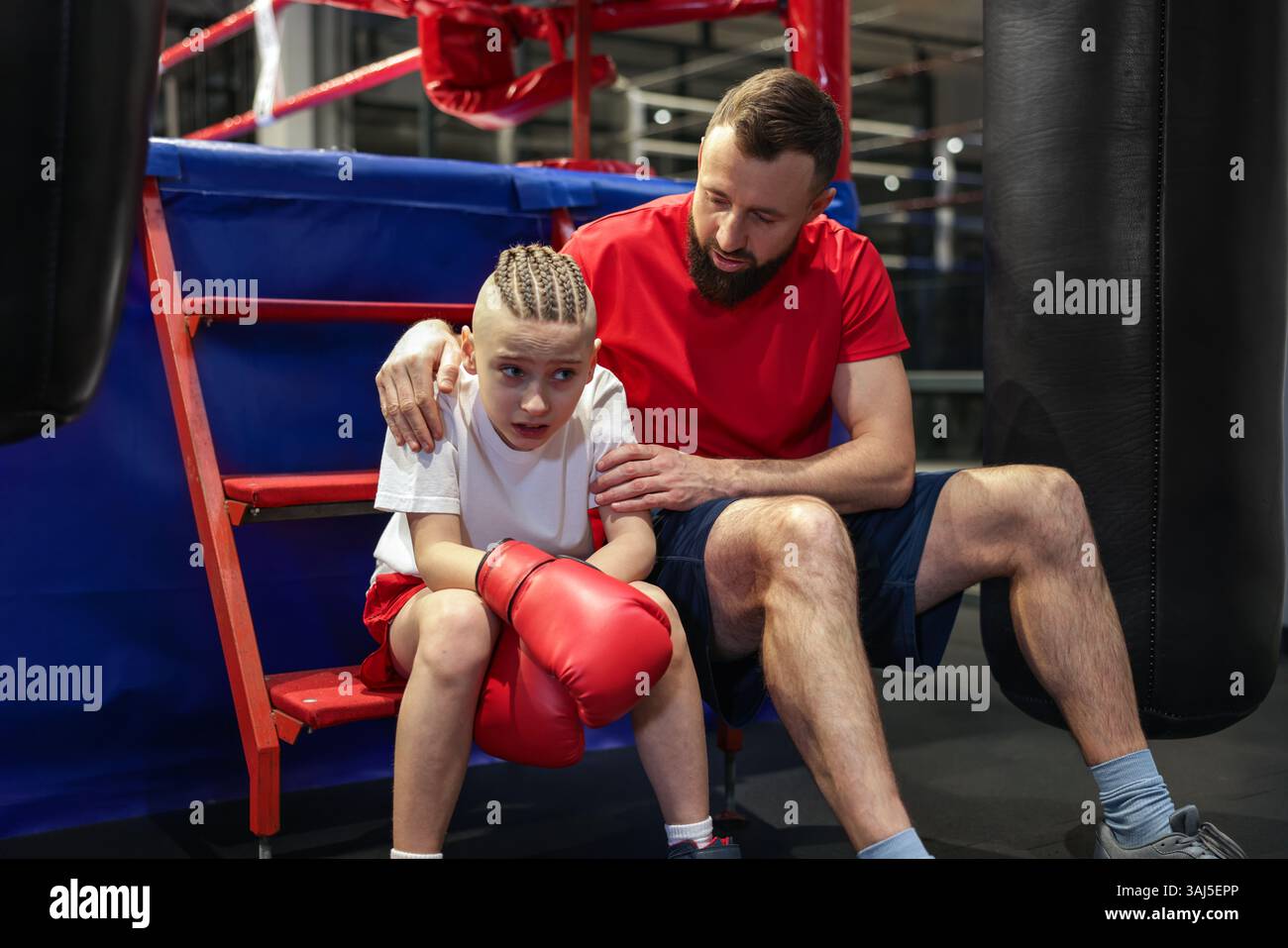 Coach comforting sad boy near boxing ring Stock Photo - Alamy