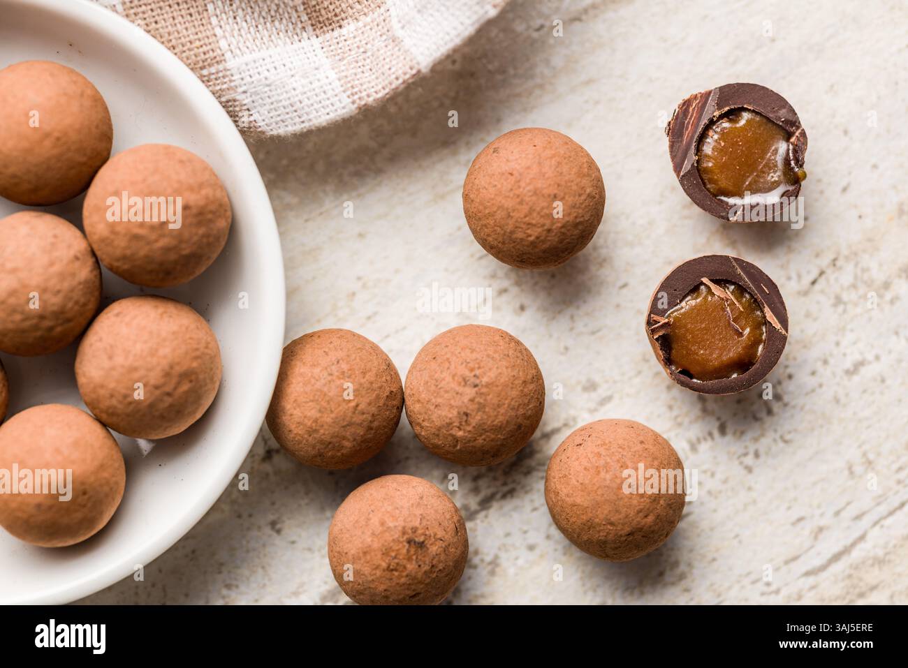 Chocolate truffles with cocoa powder and caramel filling on a kitchen ...