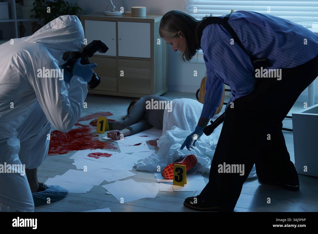 Forensic experts working at crime scene with dead woman's body indoors ...