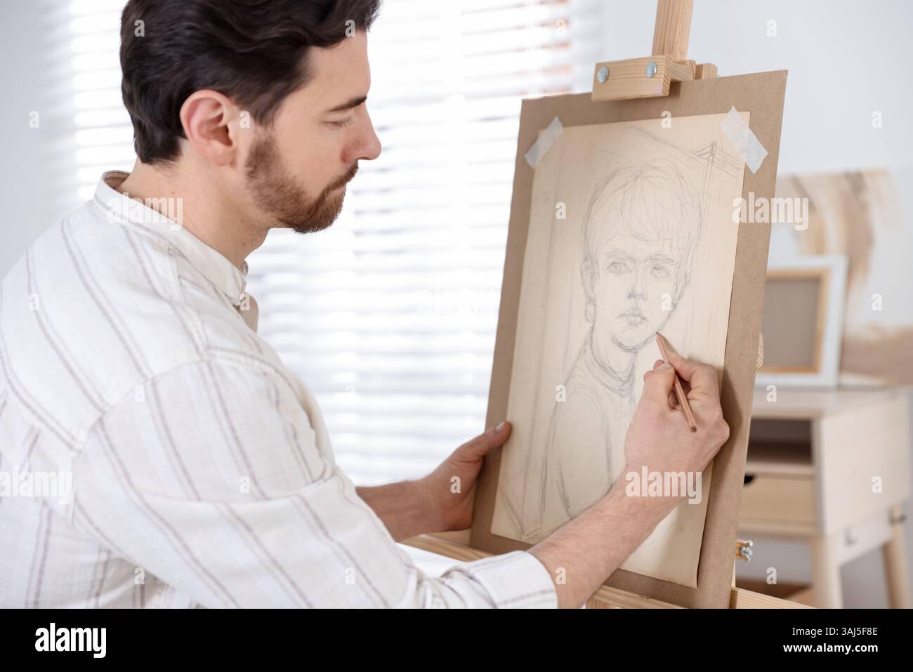 Man drawing portrait with pencil in artist's studio Stock Photo - Alamy