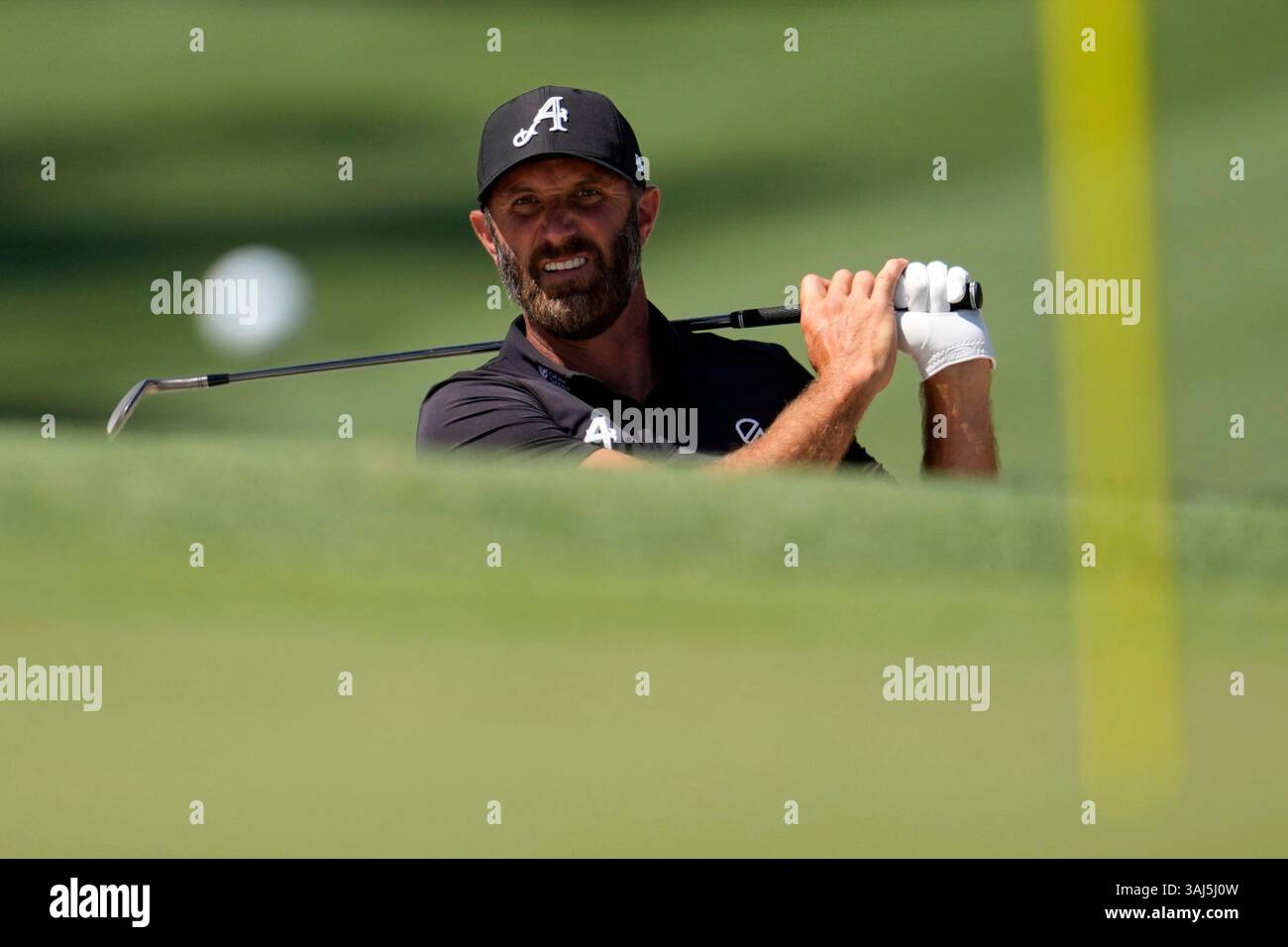 Dustin Johnson hits from the bunker on the 10th hole during the first ...