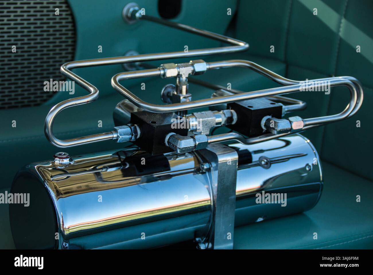 One of the chrome hydraulic tanks and tubing mounted in the trunk of a ...