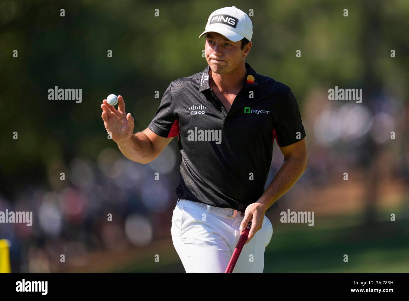 Viktor Hovland, of Norway, waves after making a putt on the 10th hole ...