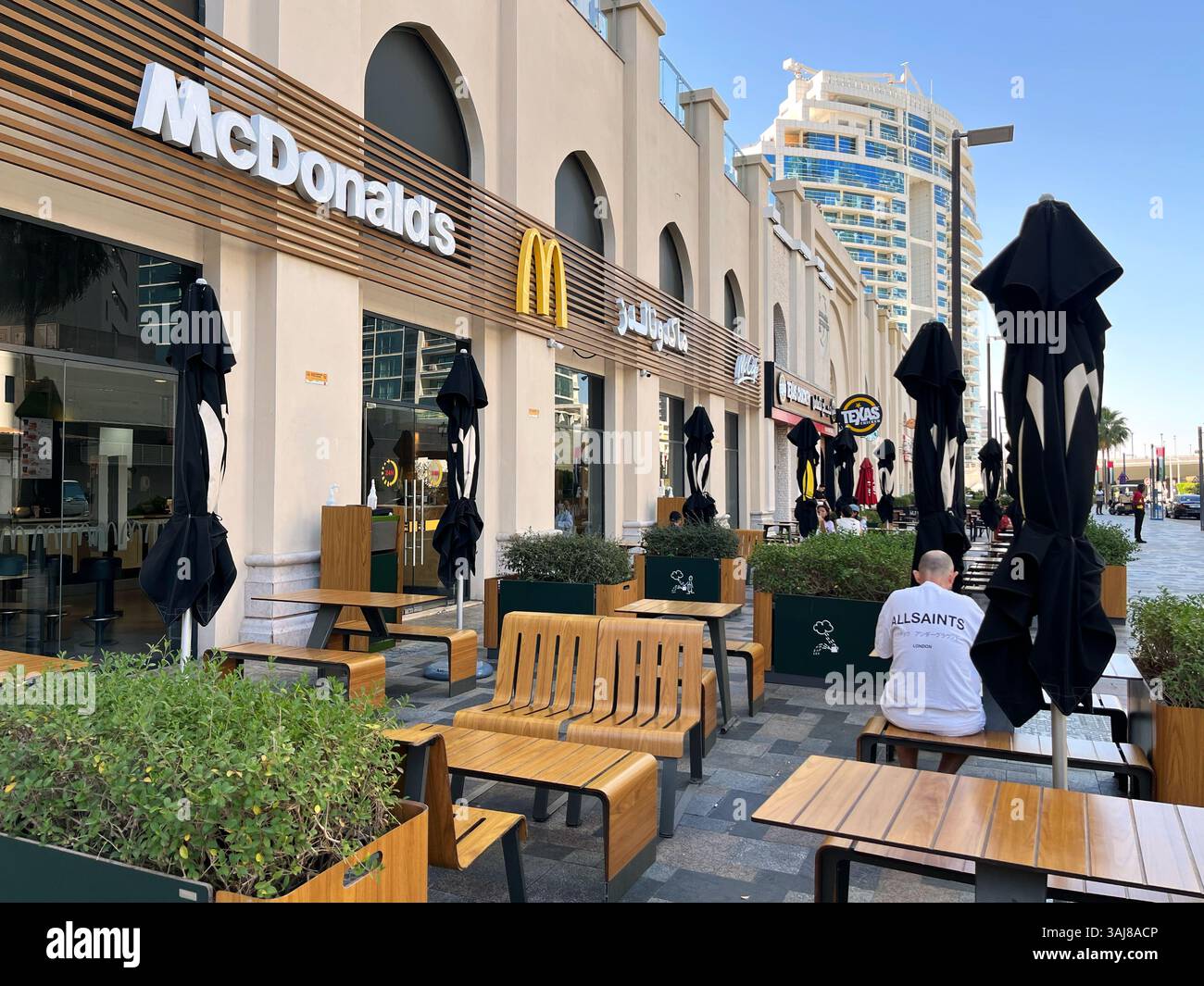 McDonald's restaurant exterior with outdoor seating. Fast food culture, global branding. Dubai ...
