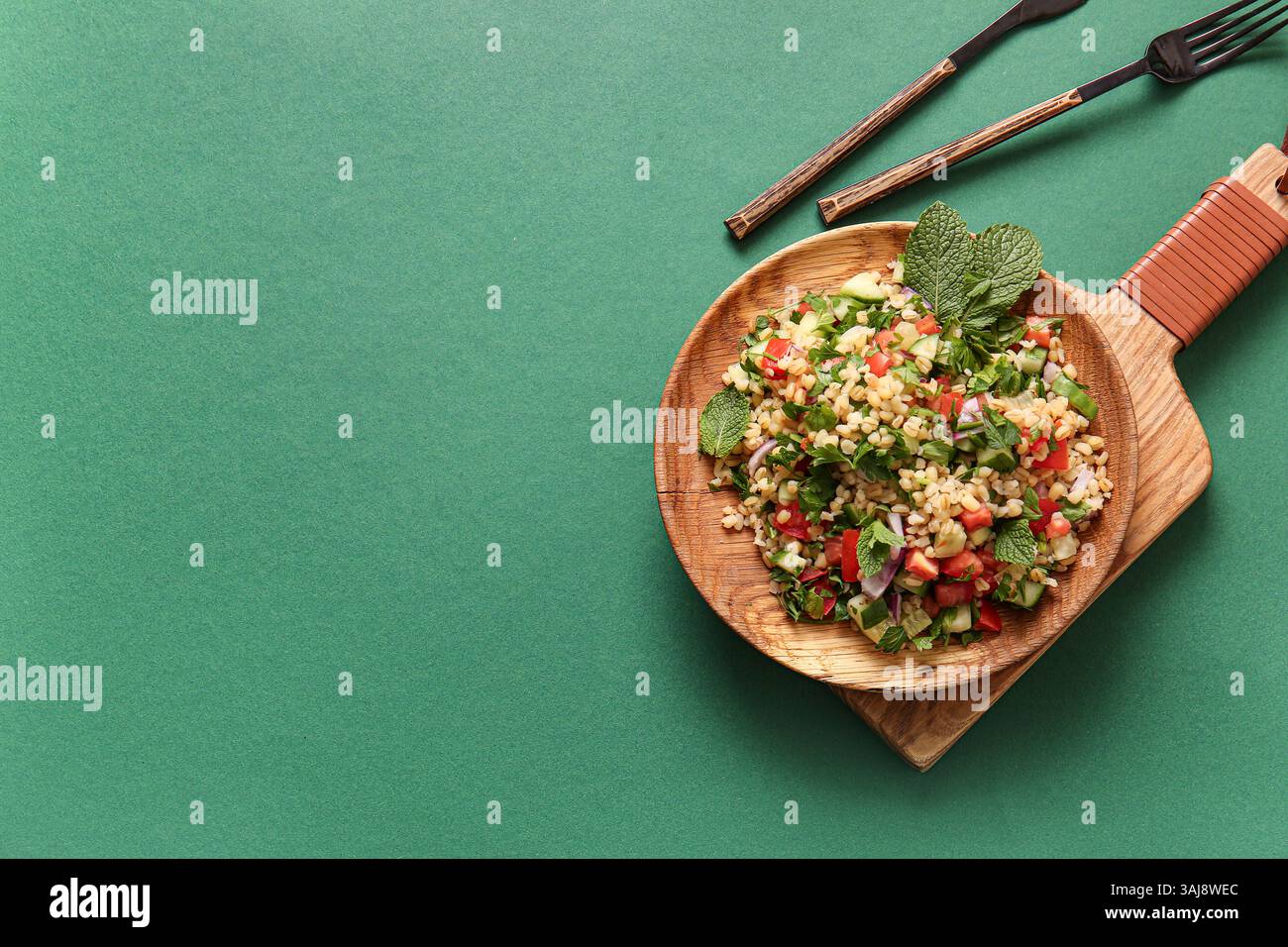 Plate with delicious tabbouleh salad on green background Stock Photo ...