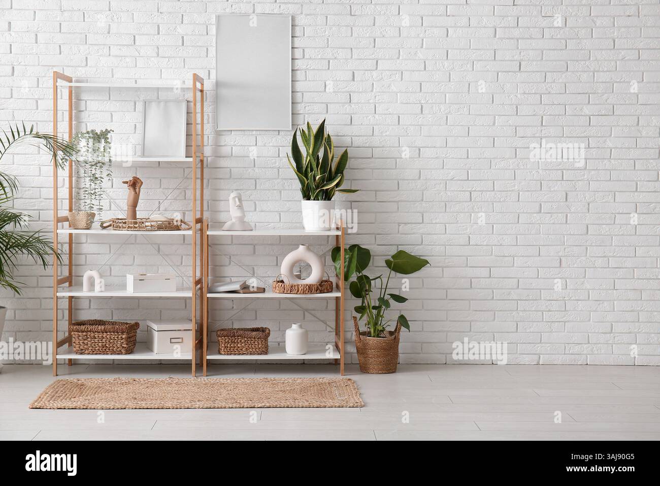 Shelving unit with statuette and houseplant near white brick wall in ...