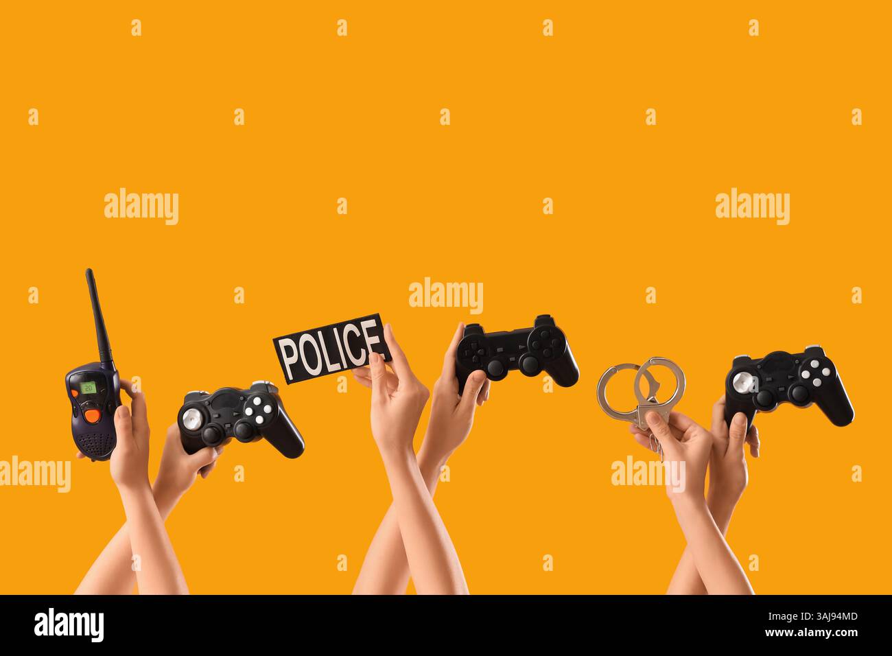 Female hands with game pads and police officer's items on yellow ...