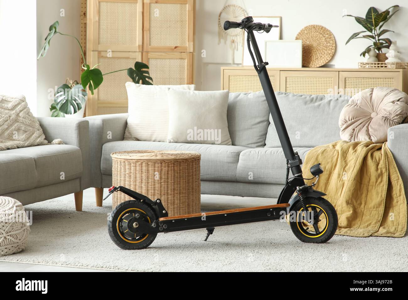 Interior of living room with electric scooter and sofas Stock Photo - Alamy