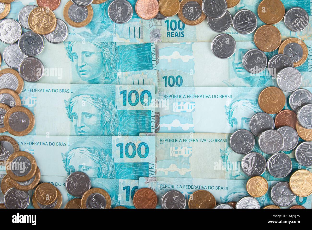 Brazilian real banknotes and coins spread out as financial and currency ...